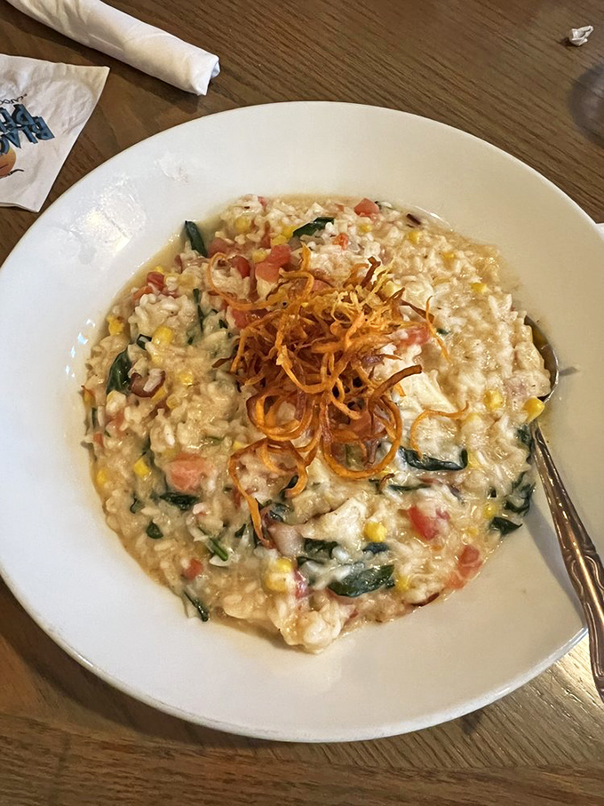 This isn't just risotto; it's a seafood treasure hunt. Each spoonful reveals corn, tomatoes, spinach, and that crispy garnish adds the perfect textural counterpoint.