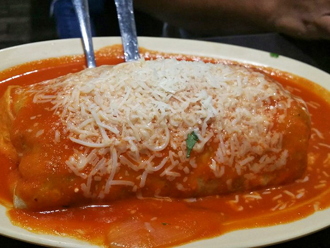 This wet burrito isn't just covered in sauce – it's swimming in flavor, with melted cheese creating that Instagram-worthy stretch we all secretly crave.