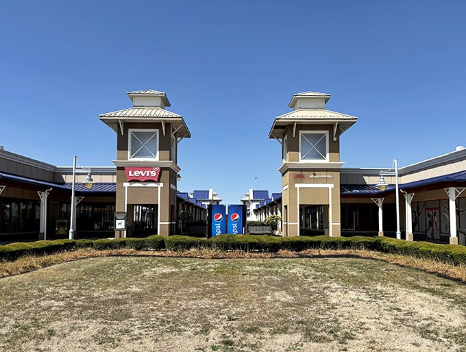 Levi's and other brand-name stores stand like sentinels at the entrance, their blue-roofed towers beckoning to denim enthusiasts everywhere.