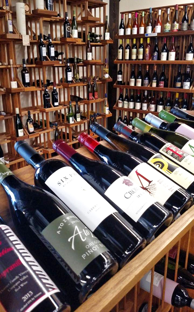 Oregon wine country comes indoors! These wooden racks showcase local Pinot Noir alongside global selections for post-shopping celebration.