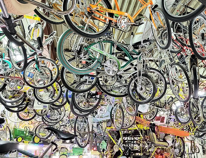 A bicycle jungle hanging from the ceiling. Somewhere in this two-wheeled forest is the Schwinn of your childhood dreams.