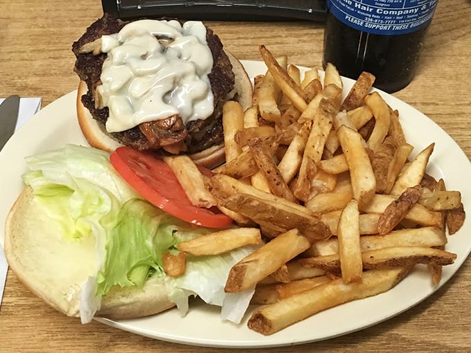 A burger crowned with creamy white sauce alongside hand-cut fries. Some meals don't need innovation&mdash;they just need proper execution.