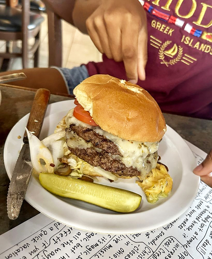 A burger so perfectly stacked it belongs in an architecture textbook, complete with the structural support of melted cheese holding it all together.