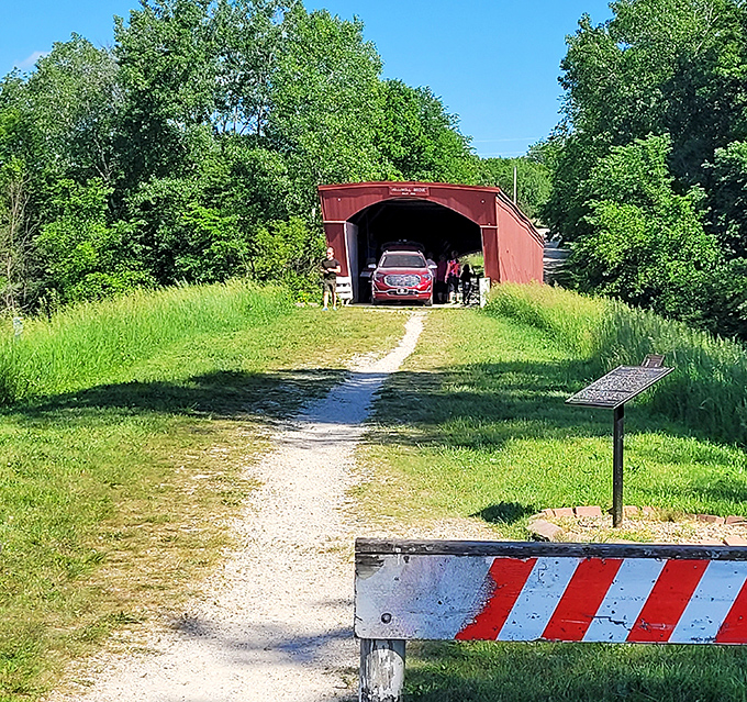 Modern meets historic as a car passes through&mdash;proof that this 19th-century marvel still serves its original purpose with quiet dignity.