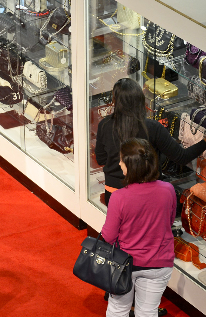 Designer handbags behind glass&mdash;proof that one person's "I'm done with this" becomes another's "I can't believe I found this!"