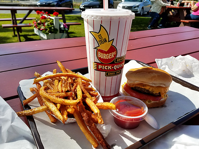 The holy trinity of roadside dining: golden fries, a perfectly proportioned burger, and a shake in a cup that proudly displays its heritage. 