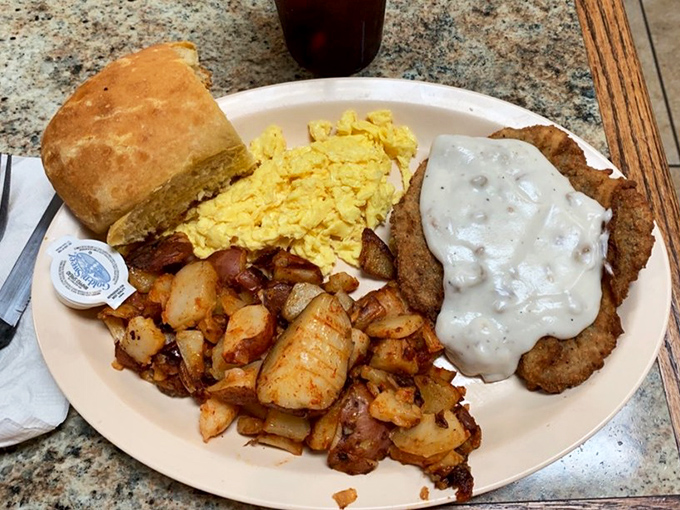 Breakfast of champions! Golden home fries, fluffy eggs, and gravy-smothered country fried steak &ndash; a plate that says "nap time" will be scheduled for later.