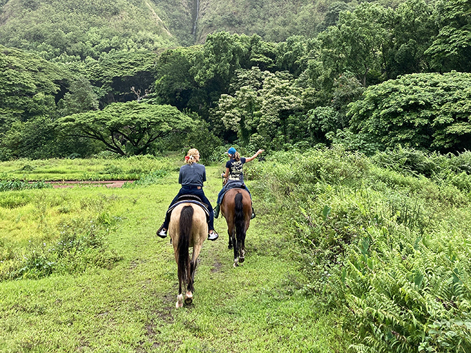 Horseback riding through Waipio Valley's lush landscape feels like galloping through a scene from Jurassic Park, minus the terrifying dinosaur chase.