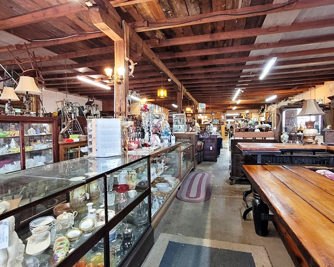 The long wooden beams and glass display cases create a museum-like atmosphere where every item waits patiently for its next chapter.