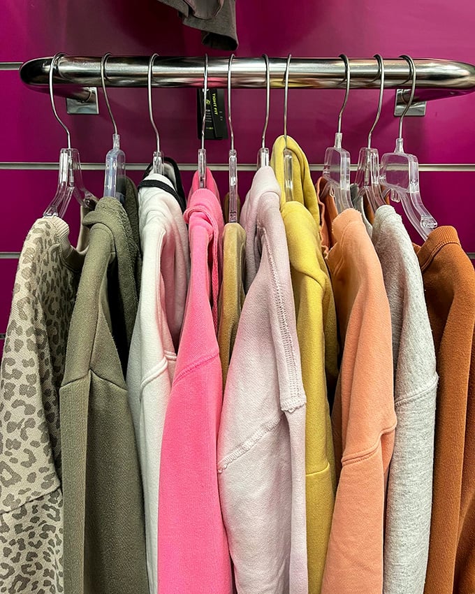 A color wheel of cozy sweatshirts hanging like paint samples, proving second-hand shopping isn't just economical&mdash;it's a full spectrum experience.