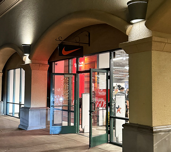 The Nike store entrance, with its iconic swoosh, promises athletic aspirations at outlet prices. Even your wallet can run faster after shopping here.