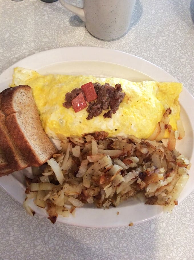 An omelet so fluffy it practically floats, crowned with hash browns that achieve crispy perfection.