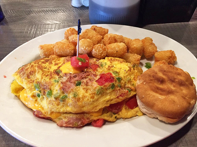 This isn't just an omelet; it's a masterpiece of morning architecture with tater tots standing by as delicious golden bodyguards.