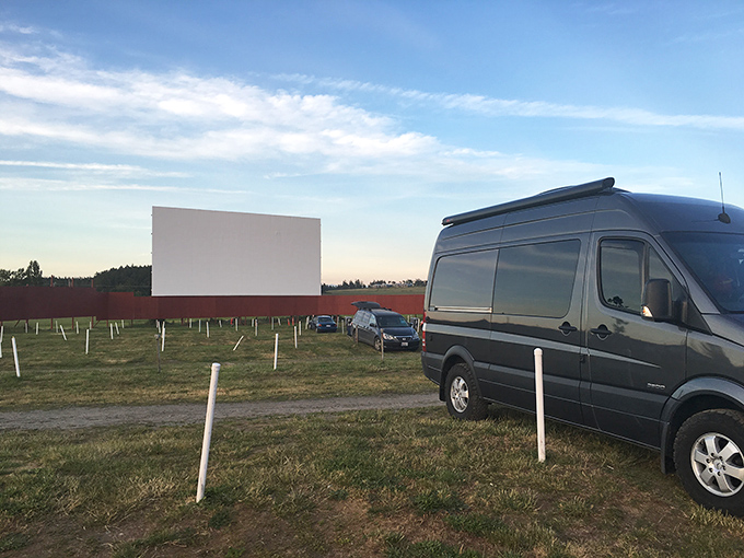 A Sprinter van claims the perfect spot as the massive screen awaits its nightly transformation into storytelling canvas.