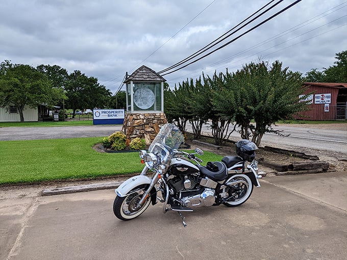 Even bikers can't resist stopping for a dime! This gleaming Harley takes a break beside the town's claim to fame, proving currency comes in all forms.