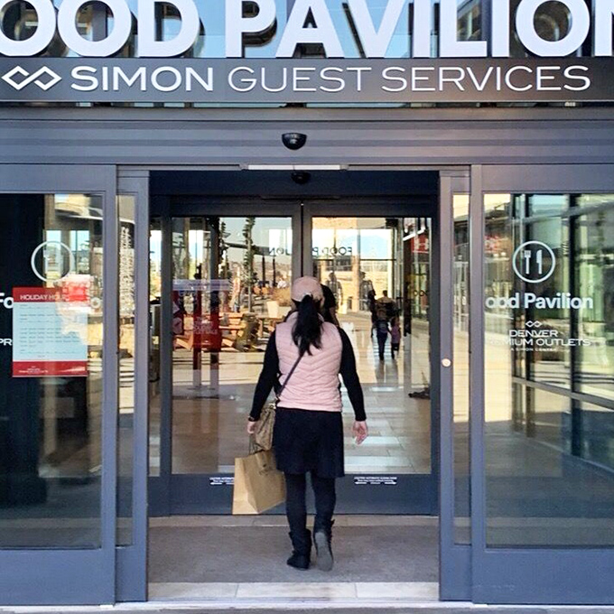 The universal "successful shopping trip" stance: shoulders back, shopping bag forward, and the confident stride of someone who just saved 70%.