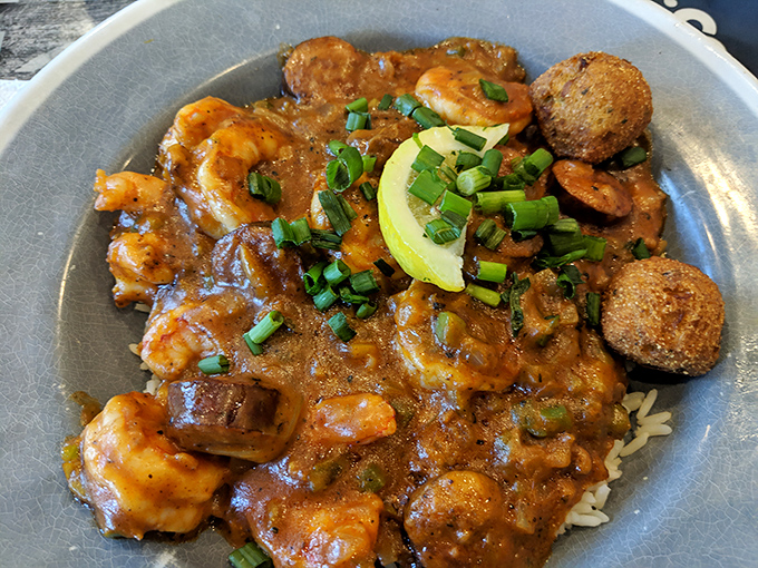 Shrimp and grits elevated to an art form &ndash; plump crustaceans swimming in savory gravy atop creamy rice, with hushpuppies standing guard on the perimeter.