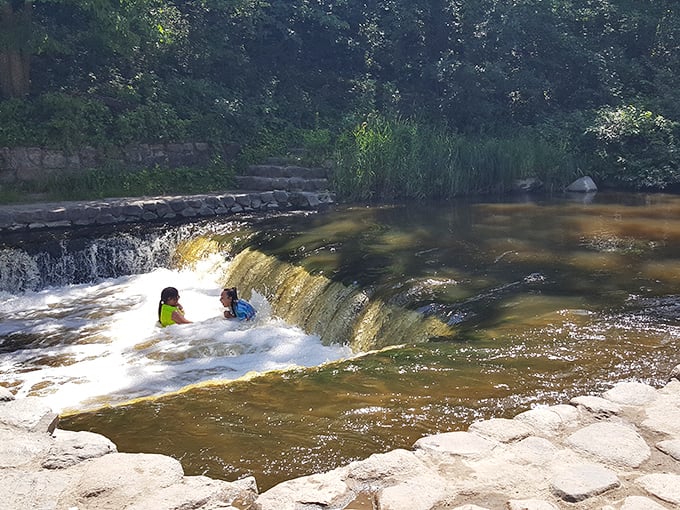 Kids have discovered nature's water park, where the dam creates the perfect sliding adventure on hot summer days.