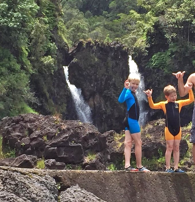 Pe'epe'e Falls creates a dramatic double cascade. The perfect backdrop for adventure-seekers enjoying Hawaii's natural playground safely from designated areas.