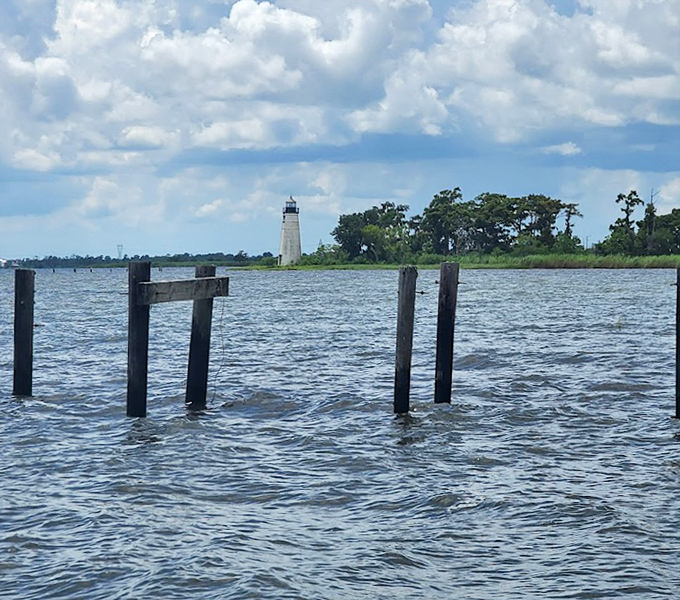 From a distance, the lighthouse appears to float on water, a white exclamation point against the vast blue canvas of sky and water.