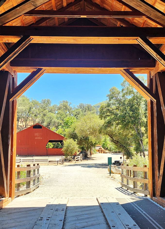 Looking out from inside the bridge reveals a charming red barn beyond. It's like stepping through a wooden time machine into California's rural past.