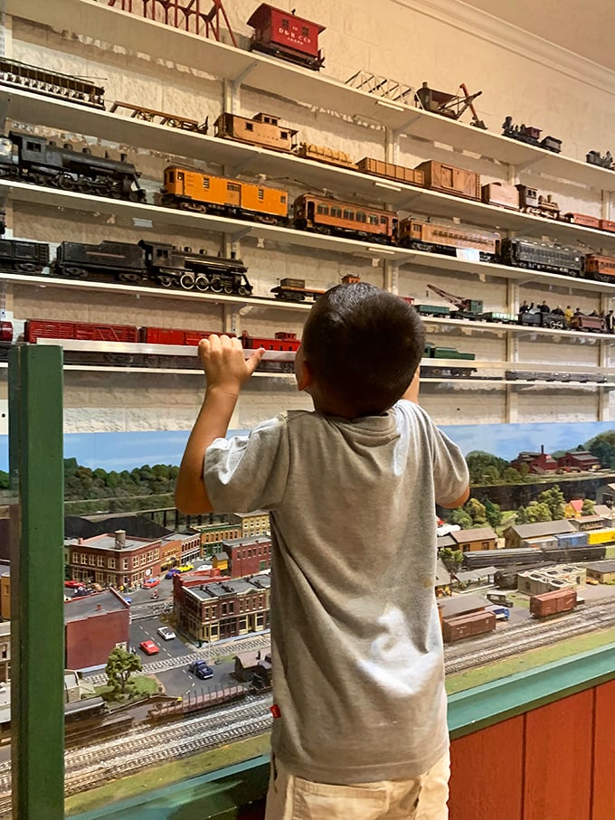 A young explorer discovers the miniature world of model trains, his wonder reminding us that some fascinations transcend generations and technology.