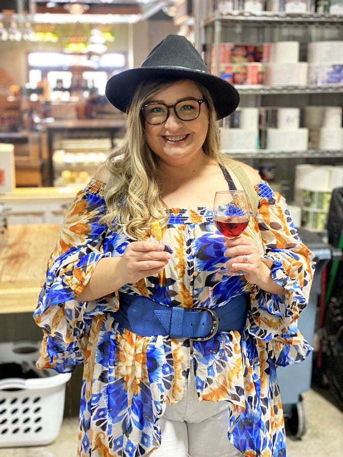 A visitor enjoys a ruby-red pour, her stylish hat suggesting wine tasting is indeed a fashion-forward occasion.