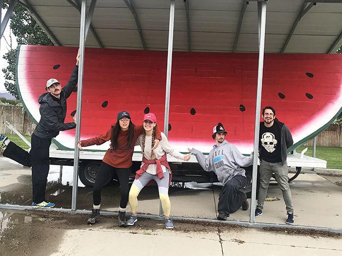The universal language of roadside attractions: striking ridiculous poses that somehow feel completely reasonable when giant fruit is involved.