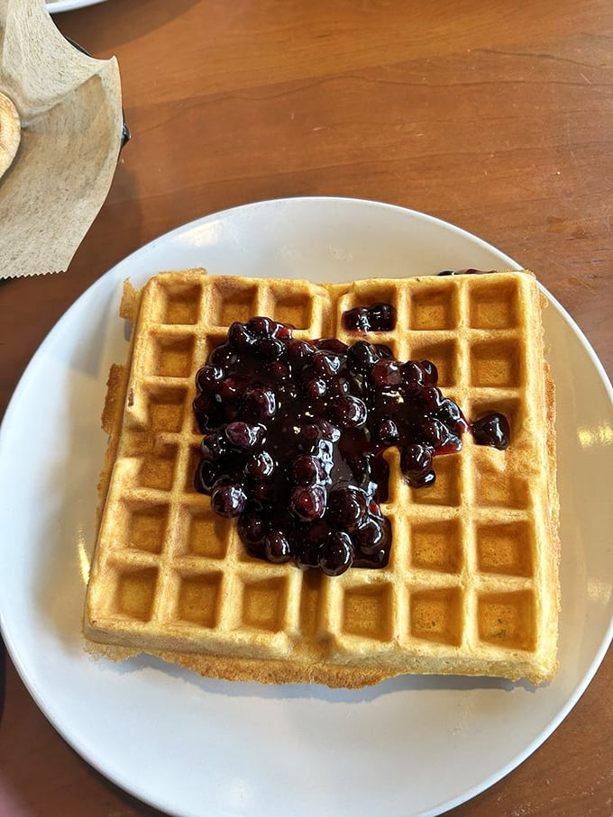 Golden perfection meets blueberry bliss! This waffle's crisp exterior and fluffy interior create the perfect canvas for those plump, juicy berries – breakfast architecture at its finest.