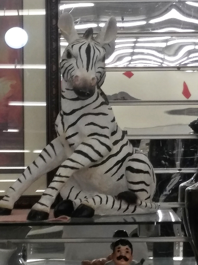This zebra figurine silently judges your shopping choices while secretly hoping you'll take him home to a less fluorescent habitat.