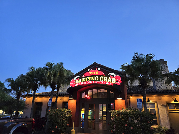 The Dancing Crab's sign glows against the twilight sky. Where Cajun meets Florida in a spicy seafood tango.
