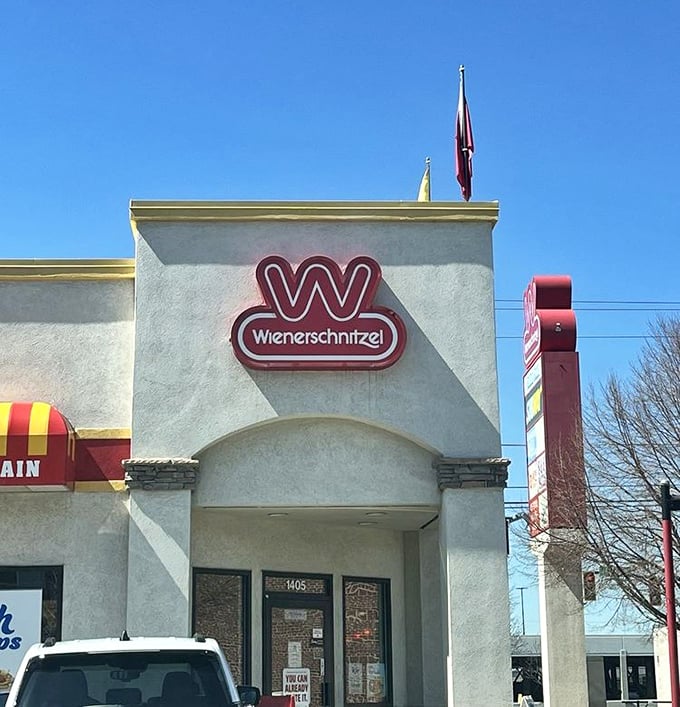 Wienerschnitzel's classic profile stands tall against the blue sky, a temple dedicated to the perfection of the humble hot dog.