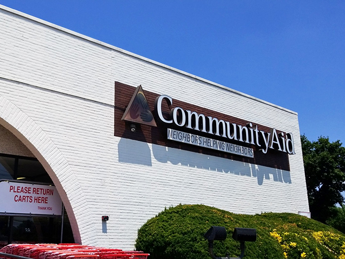 The bright white building of Community Aid stands out against the blue sky, promising treasures within its well-organized walls.