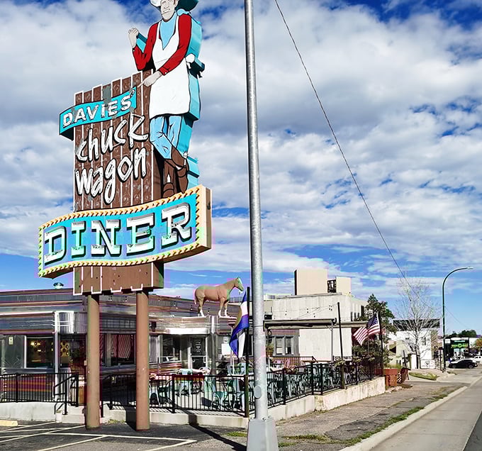The iconic cowboy sign of Davie's Chuck Wagon Diner stands tall against Colorado's blue sky. This isn't just a meal&mdash;it's a journey back to 1950s Americana.