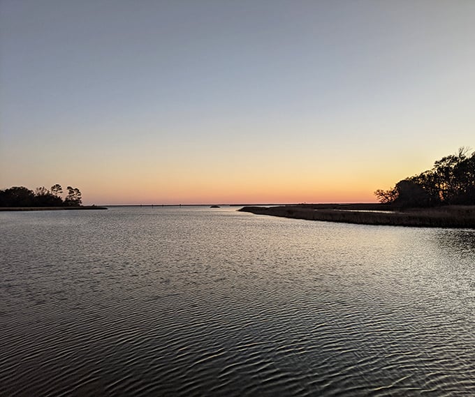 That wooden walkway leads straight to where Louisiana kisses the Gulf, and sunset paints the water in colors postcards can barely capture.