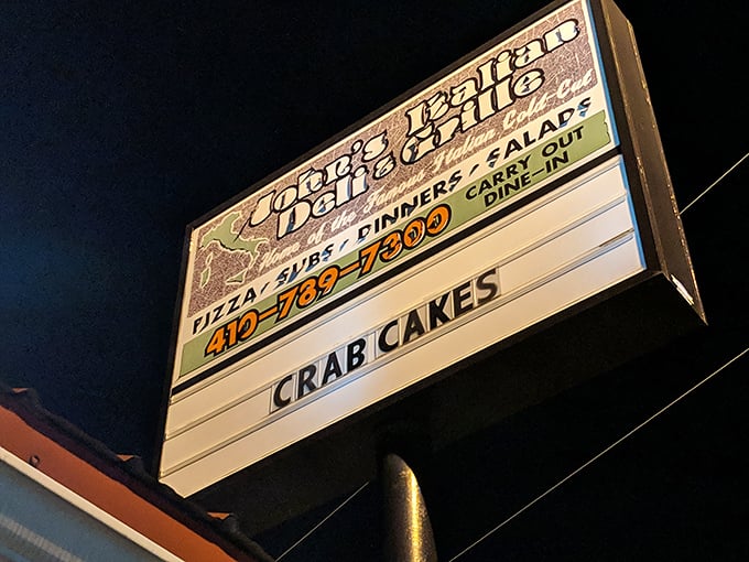 The illuminated sign for John's Italian Deli cuts through the night. When cravings call after dark, John's answers.