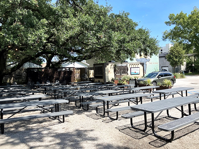 Picnic tables under ancient oaks create the perfect setting where Charleston charm meets Texas-style BBQ mastery.