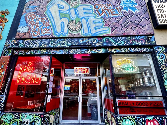 Graffiti paradise meets pizza heaven at Pie Hole. That neon "Pie Hole" sign glows like a beacon for night owls seeking the perfect slice.