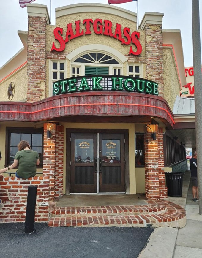The red Saltgrass sign promises what Texans know well: behind those doors awaits beef paradise with a side of coastal charm.