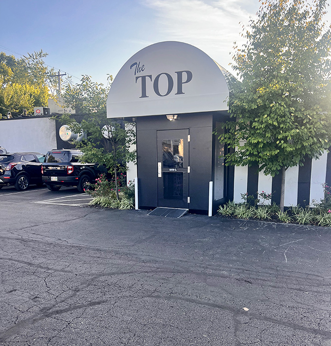 That curved entrance at The Top isn't just mid-century modern – it's a time machine to the golden age of steakhouses.