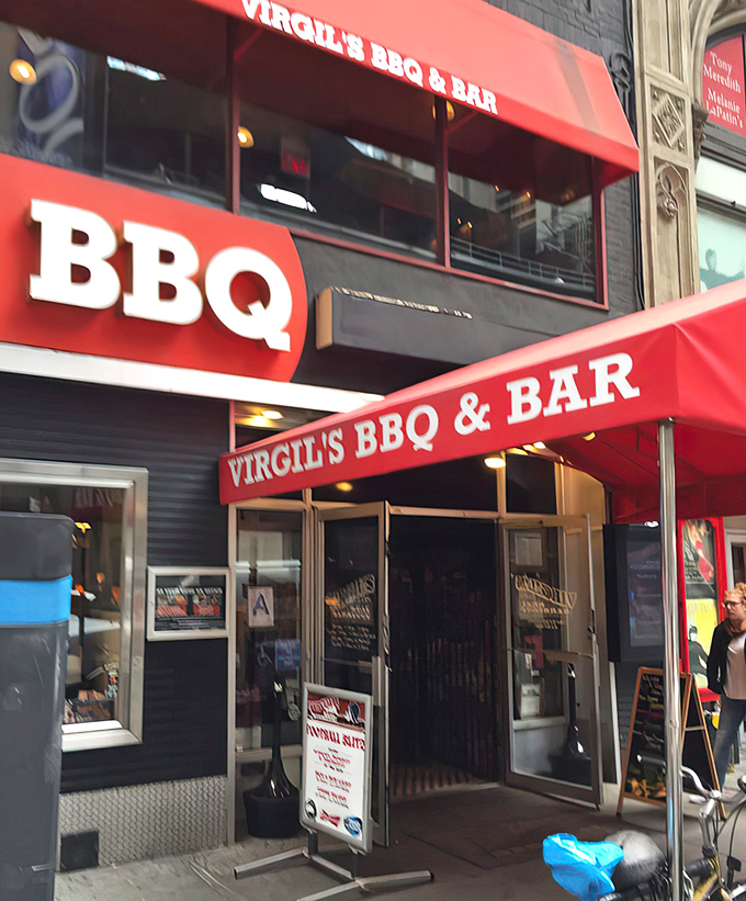 Red awnings signal serious BBQ business! Virgil's bold entrance promises a sanctuary where sauce-stained fingers and satisfied smiles are the only acceptable fashion accessories.