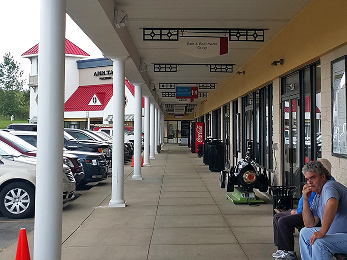 The covered walkways create a charming small-town shopping experience that feels authentically American and wonderfully welcoming.