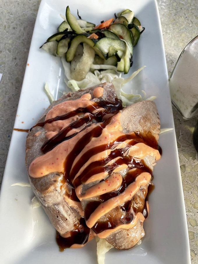 Ahi belly drizzled with dual sauces like a culinary Jackson Pollock &ndash; proof that sometimes the most humble cuts make the most magnificent dishes.