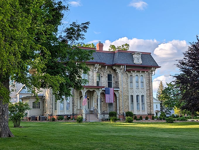 The Amos Gould House stands proudly with its American flags, a limestone testament to Victorian craftsmanship.