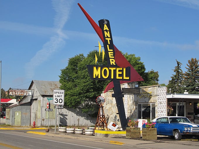 The Antler Motel's vintage sign stands tall against the Wyoming sky, a neon-bright reminder of road trips from a simpler era.