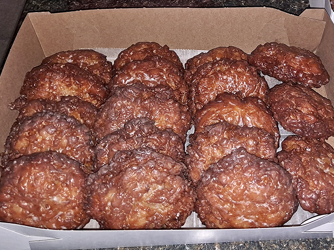 These apple fritters aren't just fried dough—they're golden-brown orbs of happiness that crackle with each bite and leave your fingers deliciously sticky.