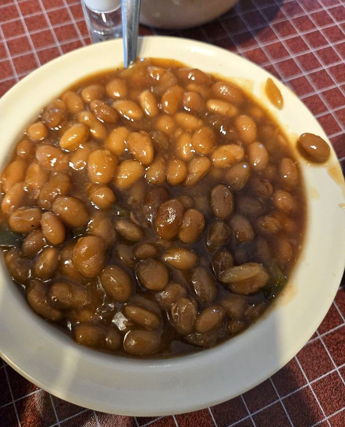 Baked beans simmered to that perfect sweet-savory balance &ndash; the kind that make you wonder if grandma snuck into the kitchen when nobody was looking.