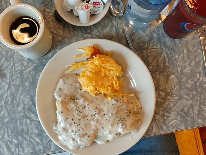 Sausage gravy that could make a vegetarian question their life choices, smothering a biscuit that clearly died happy.