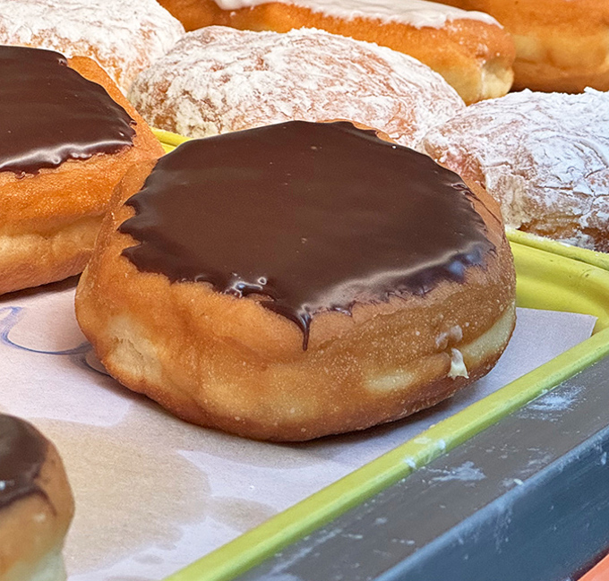 The Boston cream masterpiece sits there looking all innocent, but one bite reveals its deliciously devious chocolate-covered cream-filled secret within.