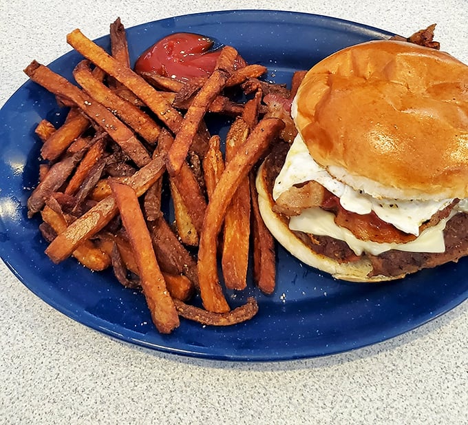 Sweet potato fries flank a breakfast burger that laughs in the face of conventional breakfast-lunch boundaries.